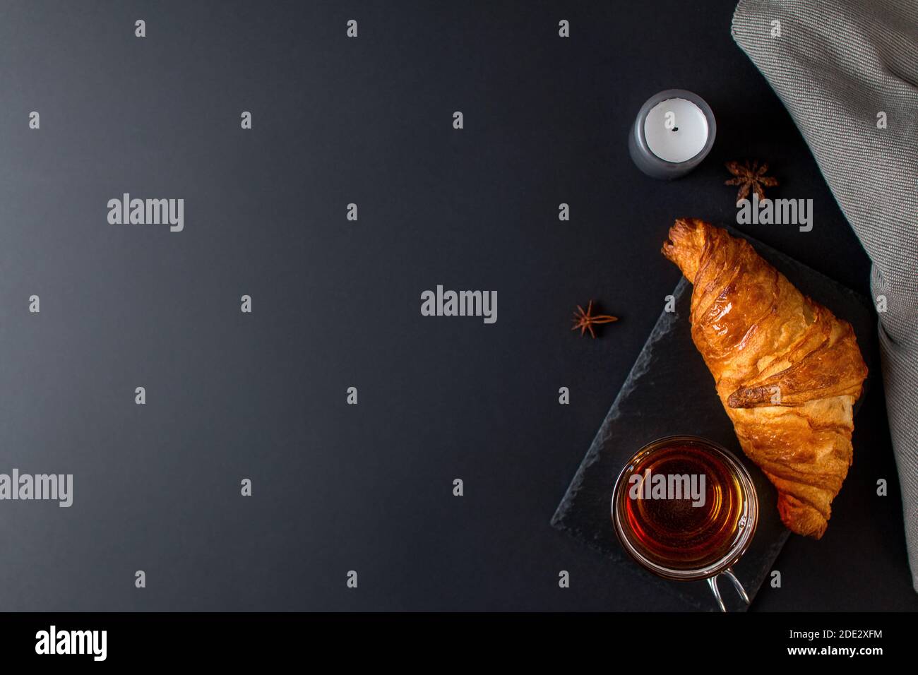 A top view of croissant bread with star anise tea isolated on black ...