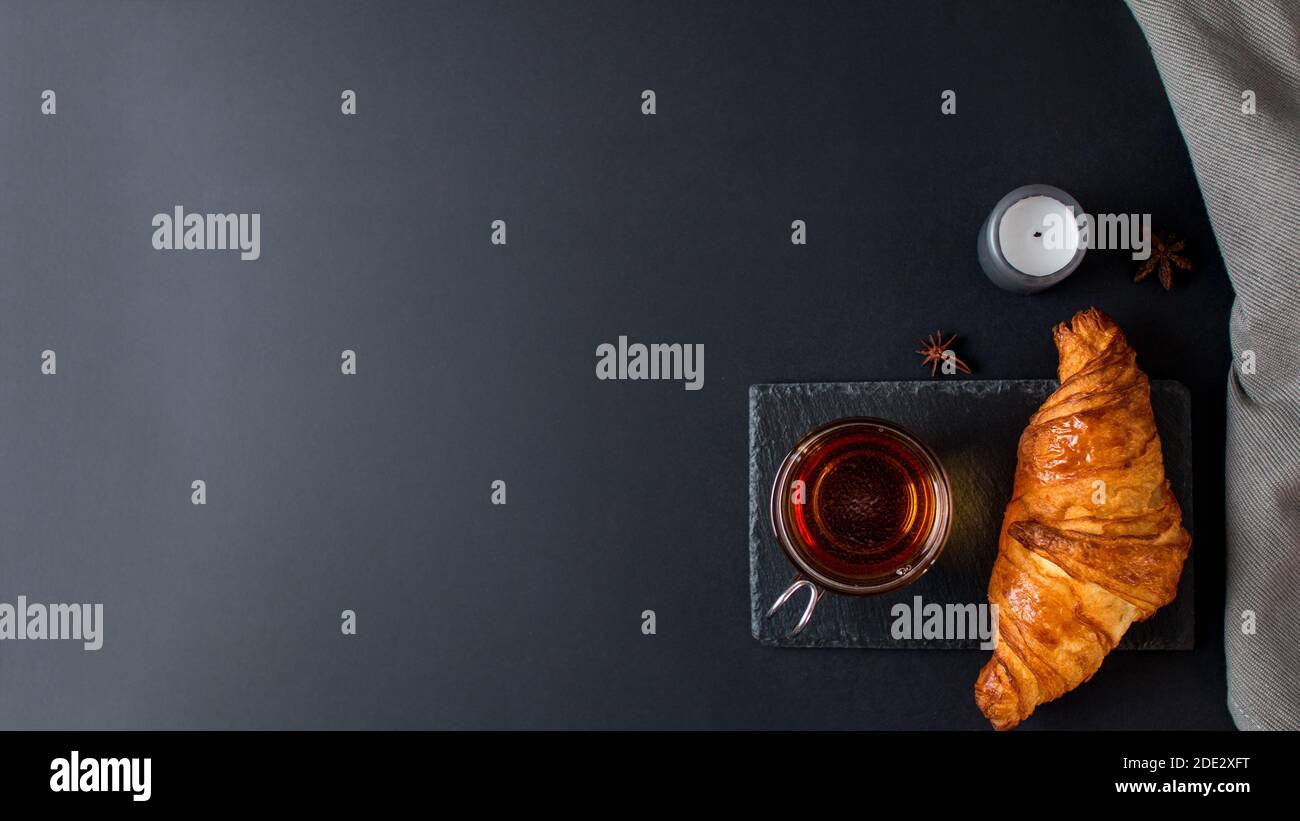 A top view of croissant bread with star anise tea isolated on black ...