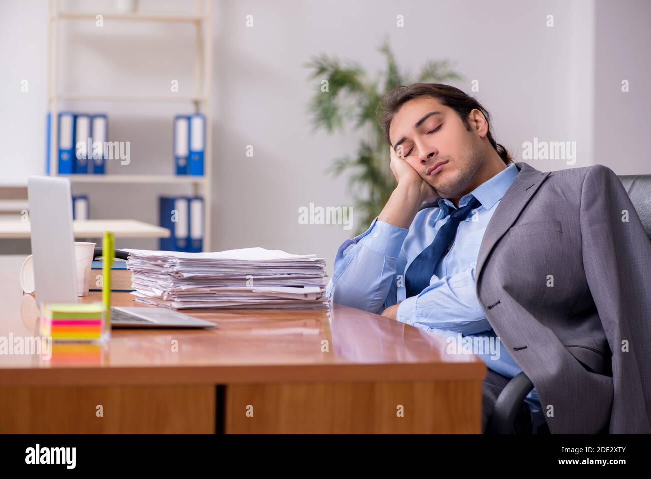 Young employee sleeping in the office Stock Photo - Alamy