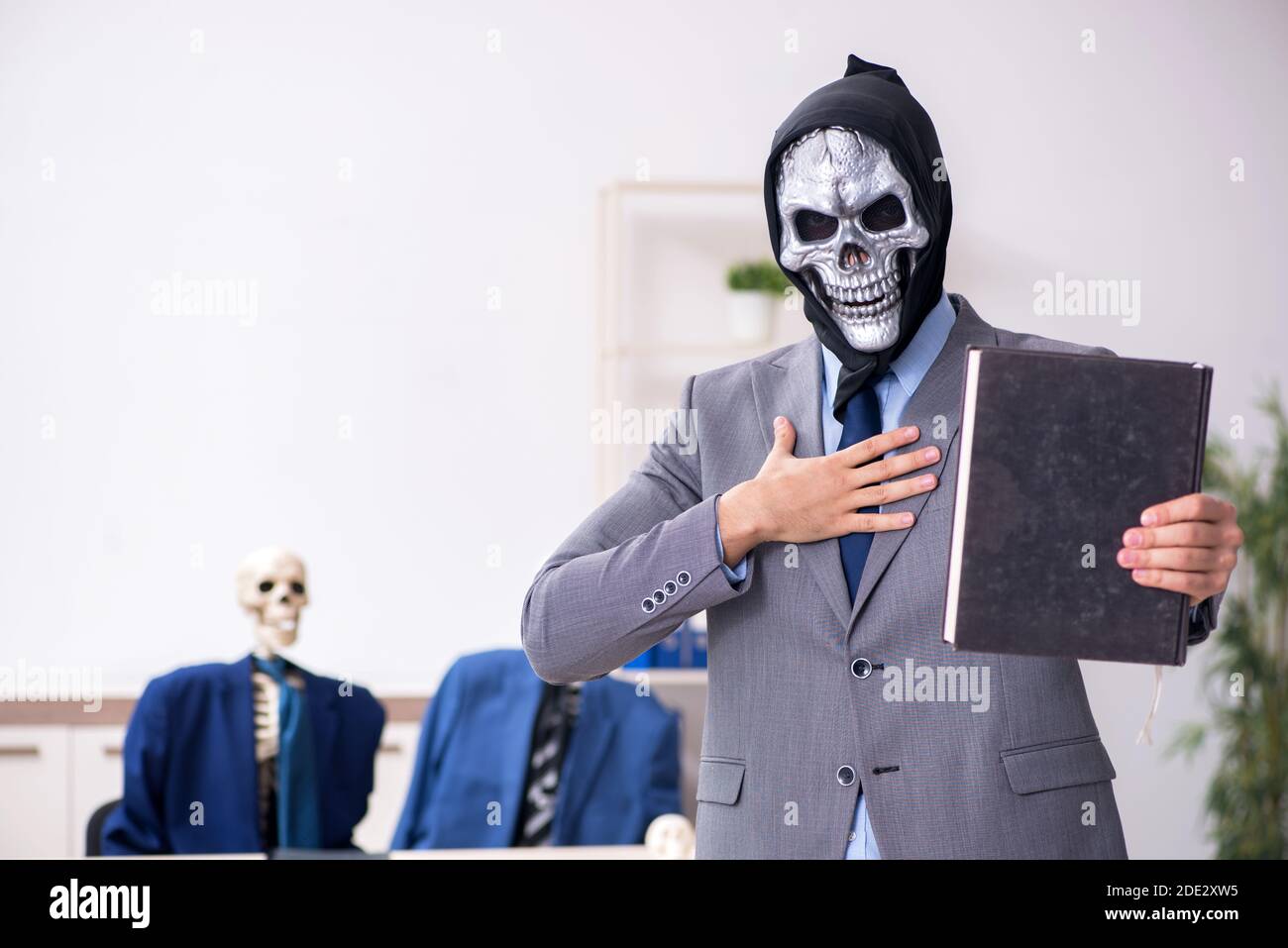 Funny business meeting with the devil and skeletons Stock Photo - Alamy