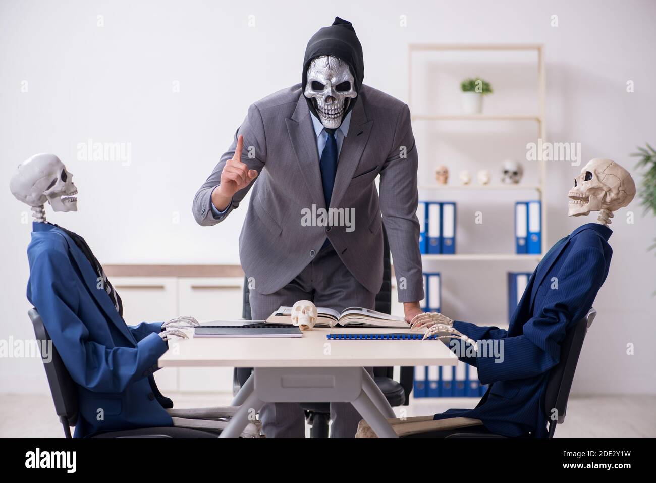 Funny business meeting with the devil and skeletons Stock Photo - Alamy