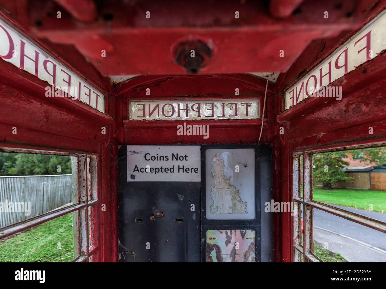 Abandoned old red phone box with broken smashed glass and peeling red ...