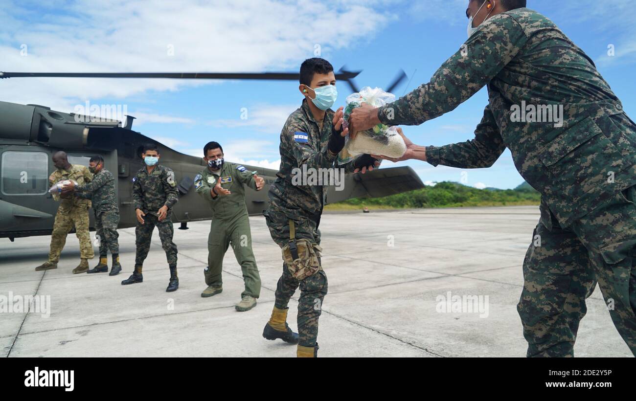 U.S. and Honduran soldiers and airmen load humanitarian aid onto a UH ...