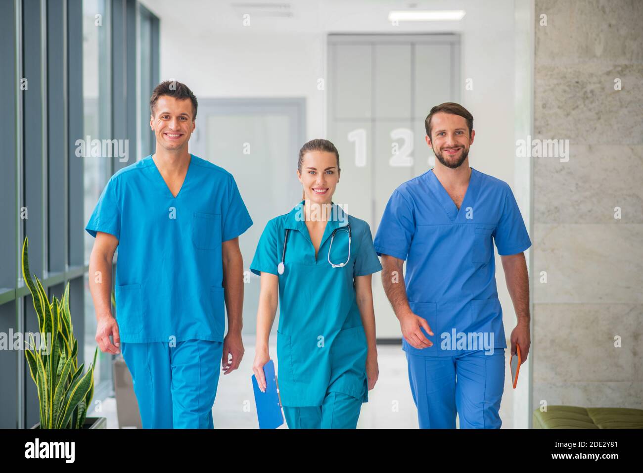 Three doctors walking together in the hospital corridor Stock Photo - Alamy