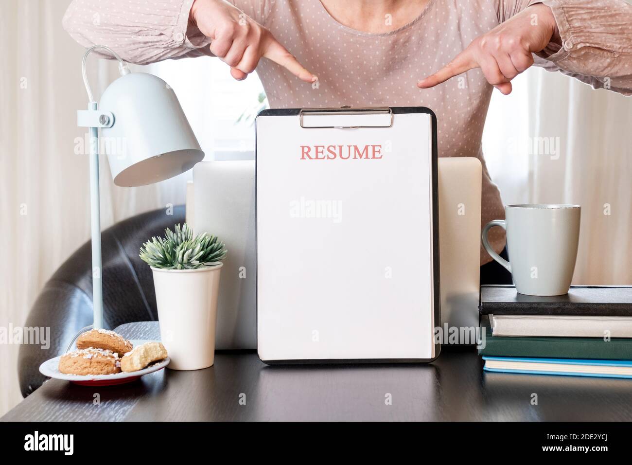 Woman hands holding resume application near her workplace with laptop ...