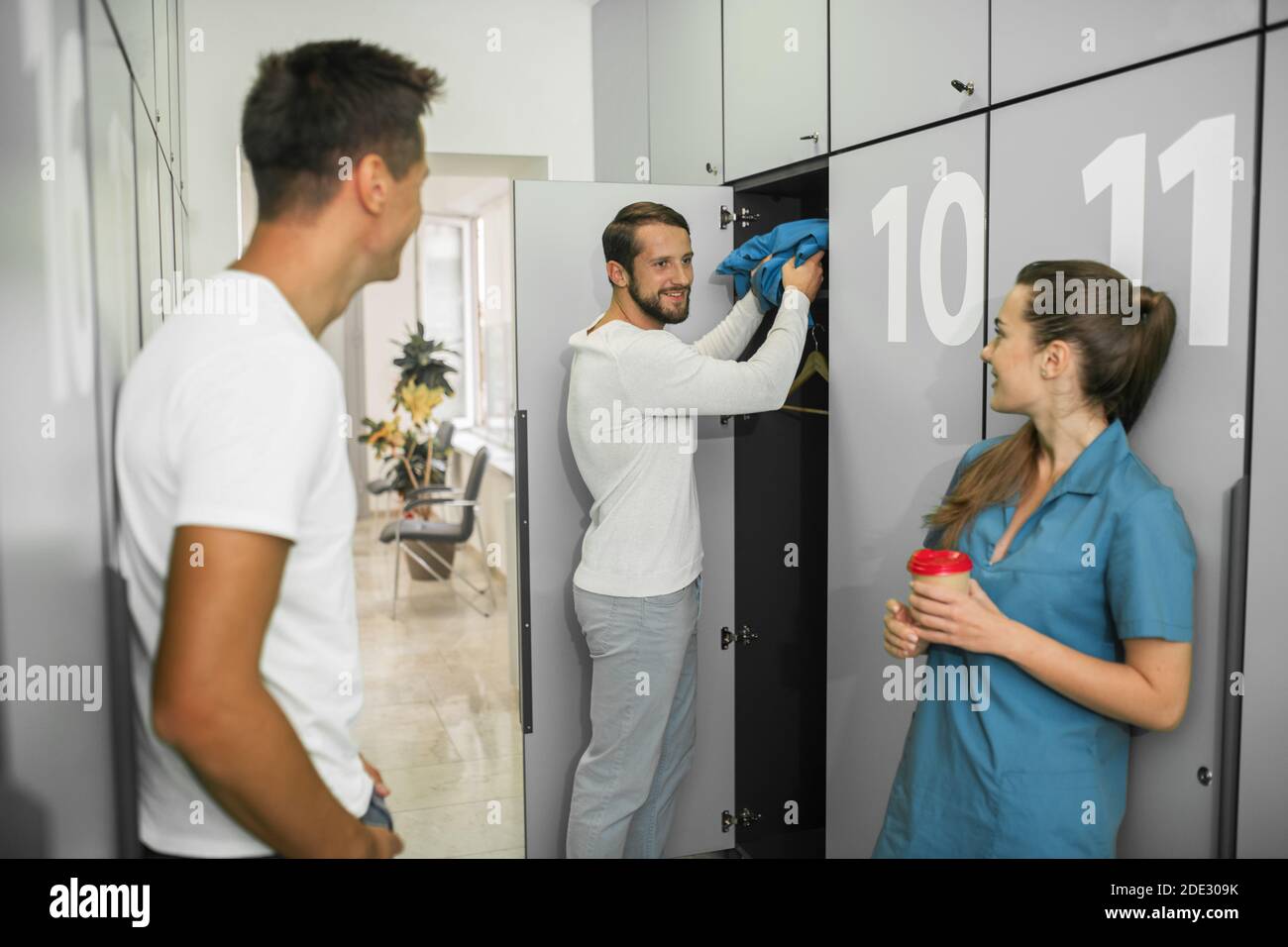 Group of people standing in the changing room and talking Stock Photo ...