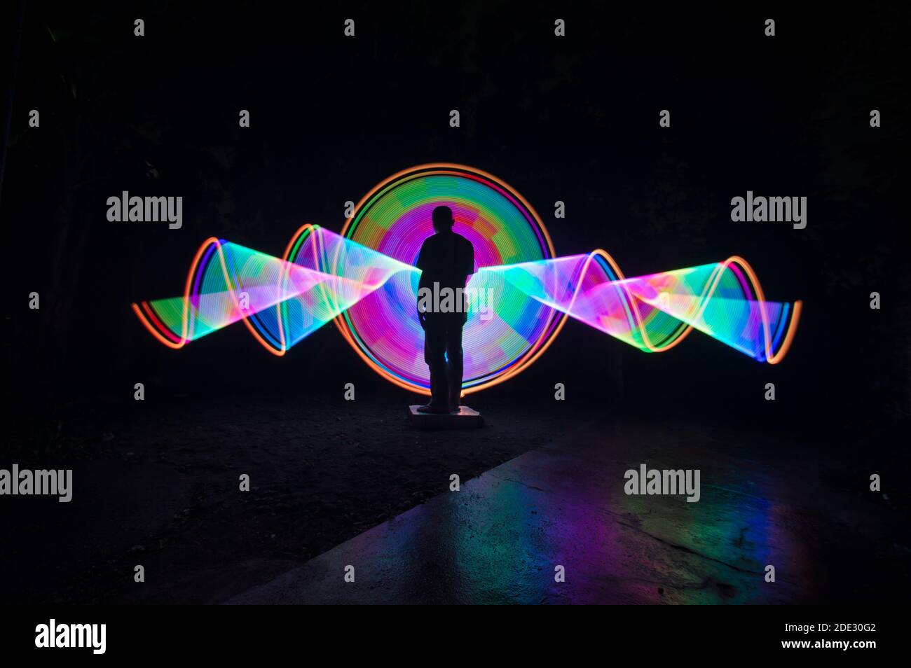 One person standing alone against beautiful Colourful LED light ...