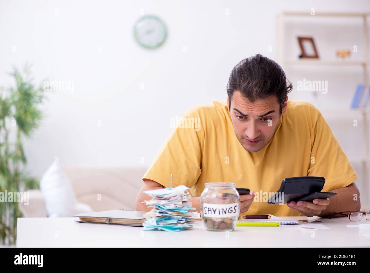 Young man in the budget planning concept Stock Photo - Alamy