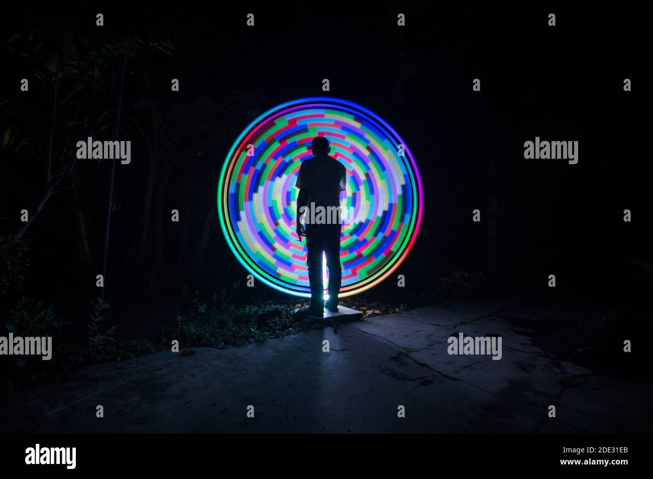 One person standing alone against beautiful Colourful LED light ...