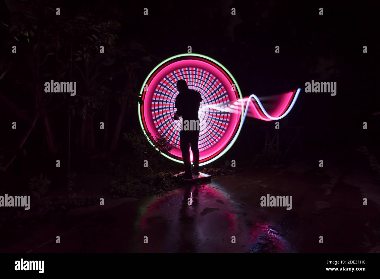 One person standing alone against beautiful Colourful LED light ...