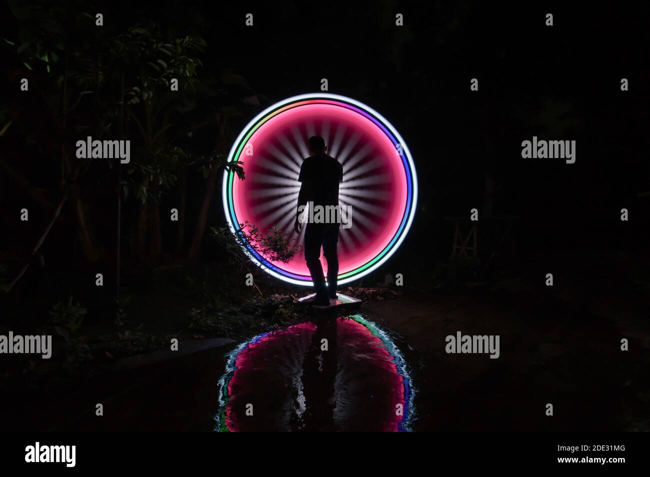 One person standing alone against beautiful Colourful LED light ...