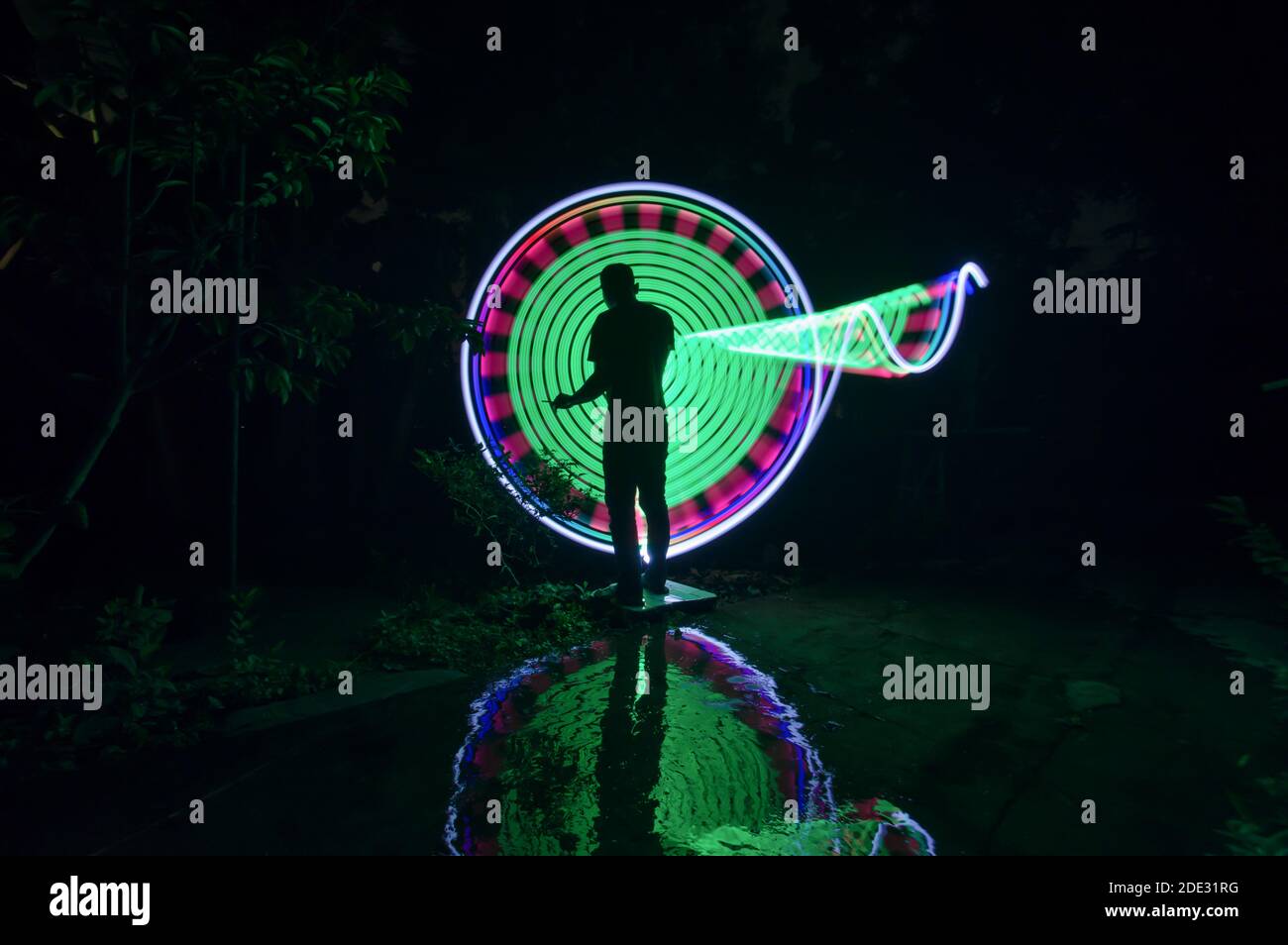 One person standing alone against beautiful Colourful LED light ...