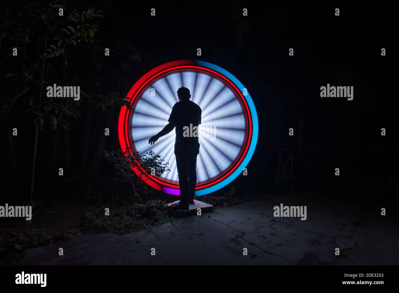 One person standing alone against beautiful Colourful LED light ...