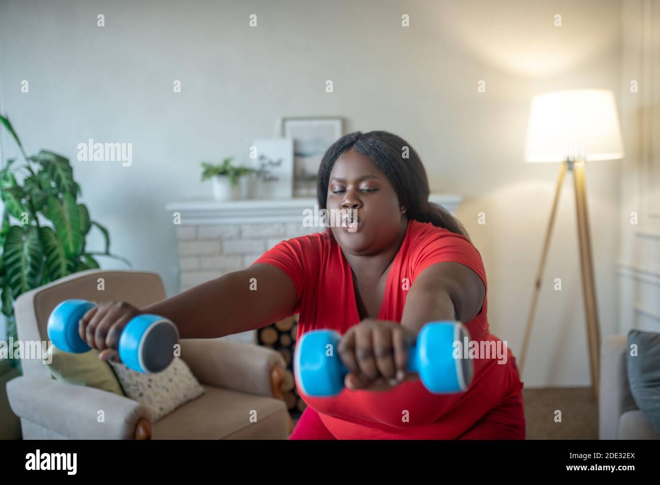 Plus size african american woman doing squats with dumbbells Stock ...