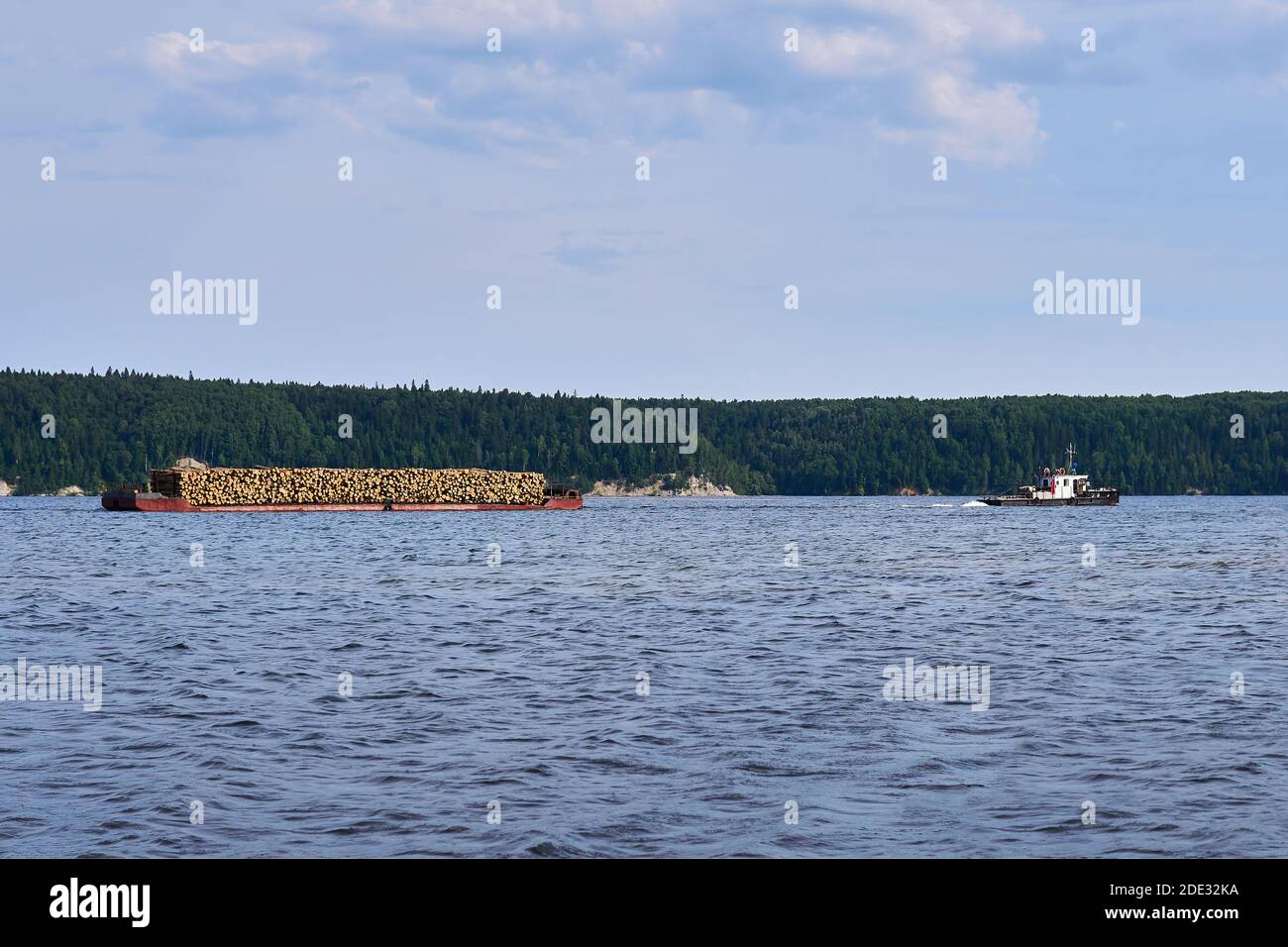transportation of timber along the river using a barge towed by a tug ...