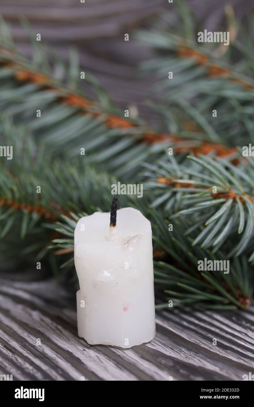 Candle stub and fir branches. On black pine boards Stock Photo - Alamy