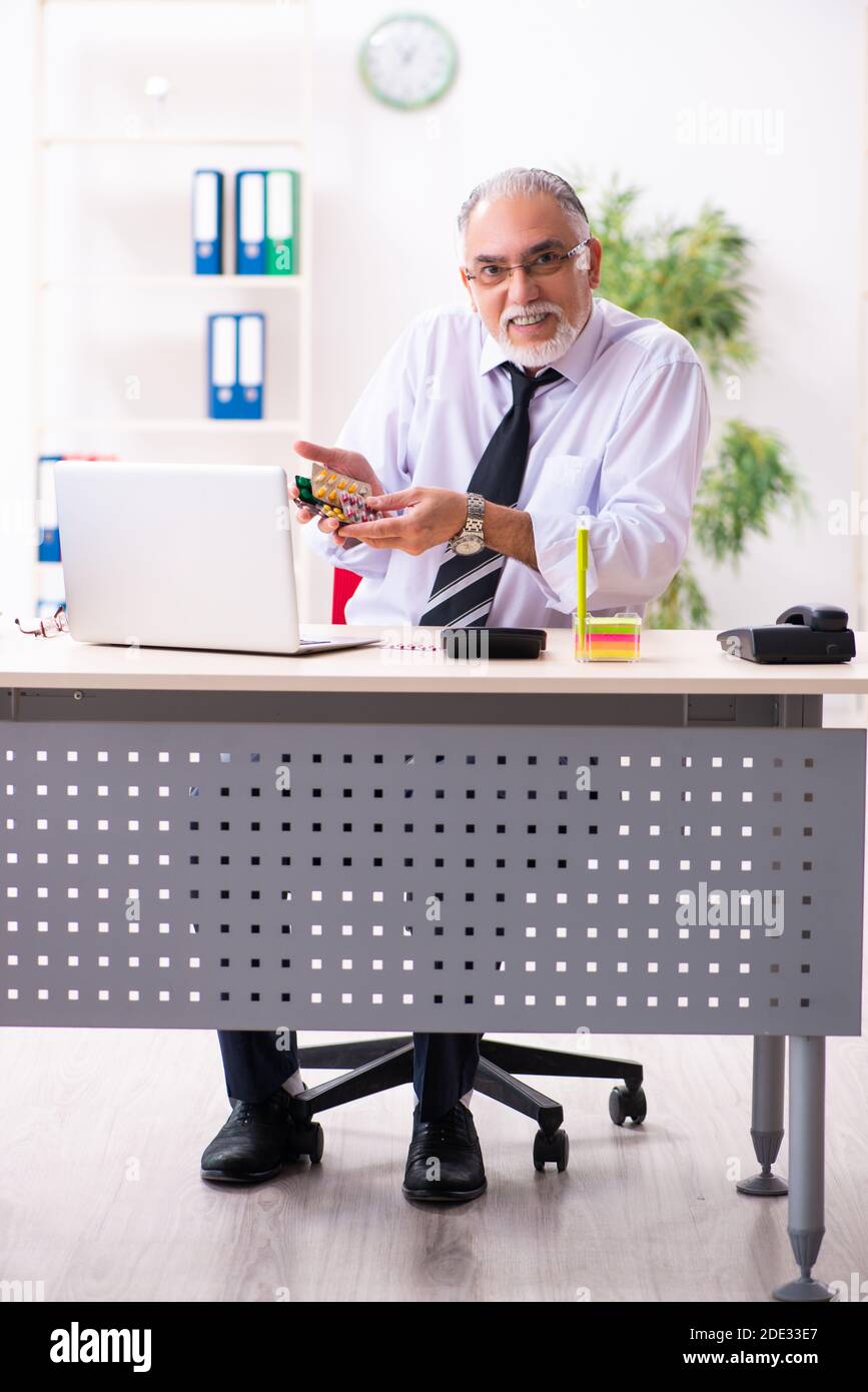 Old sick employee suffering at the workplace Stock Photo - Alamy