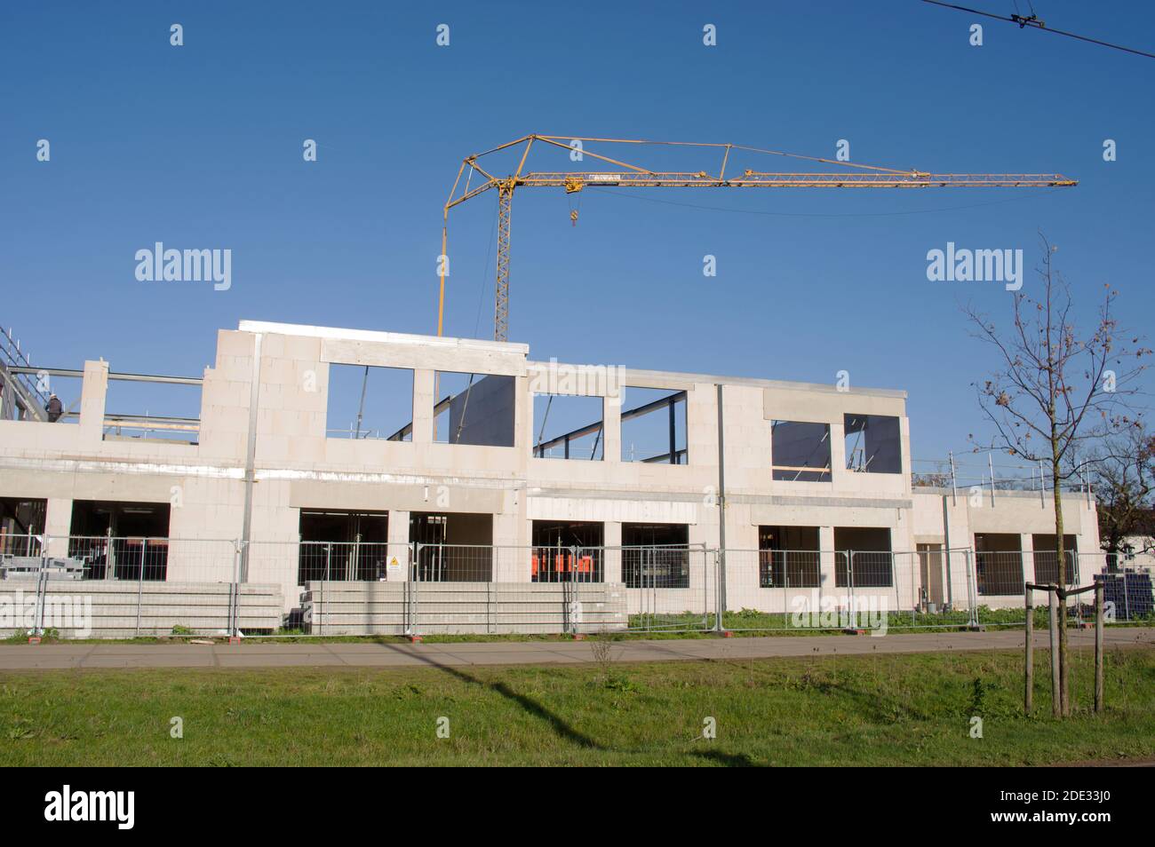 Skeleton of a building under construction with a large yellow crane ...