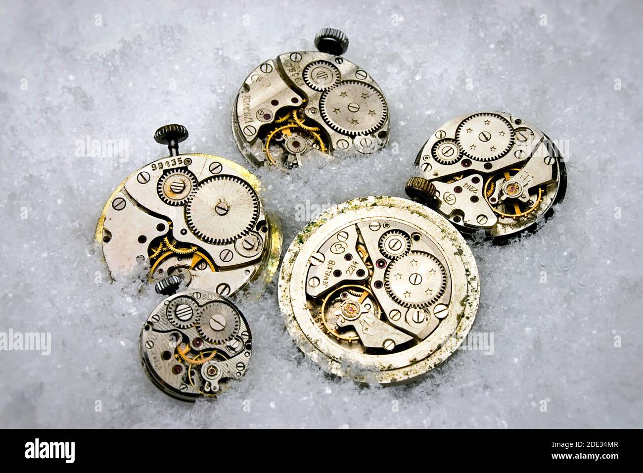 Metal clock mechanisms lie in the snow Stock Photo - Alamy