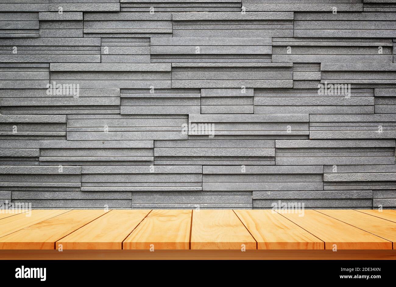 Wooden table on stone wall background Stock Photo - Alamy