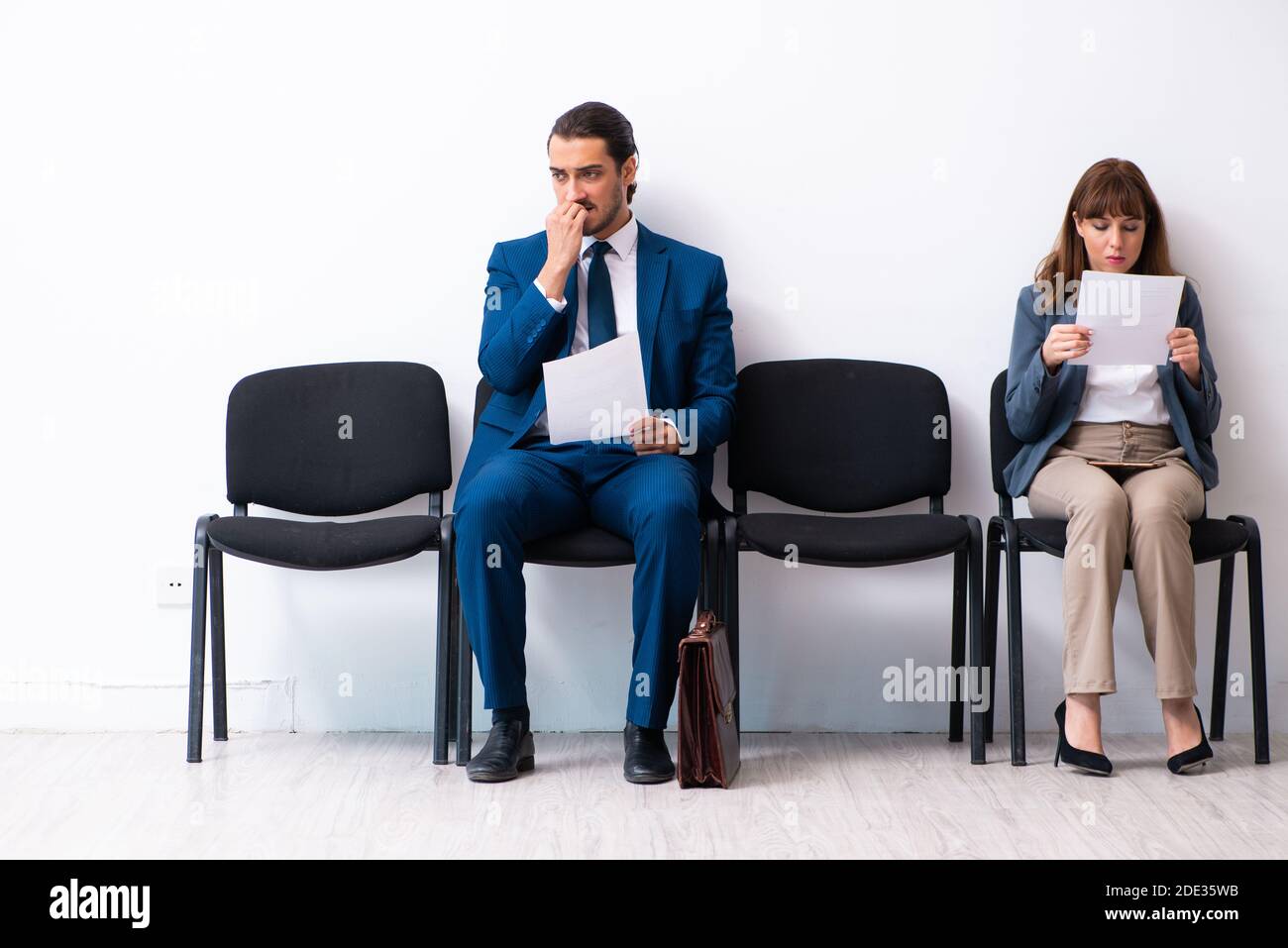 Businessman and businesswoman waiting for an interview at hall Stock ...