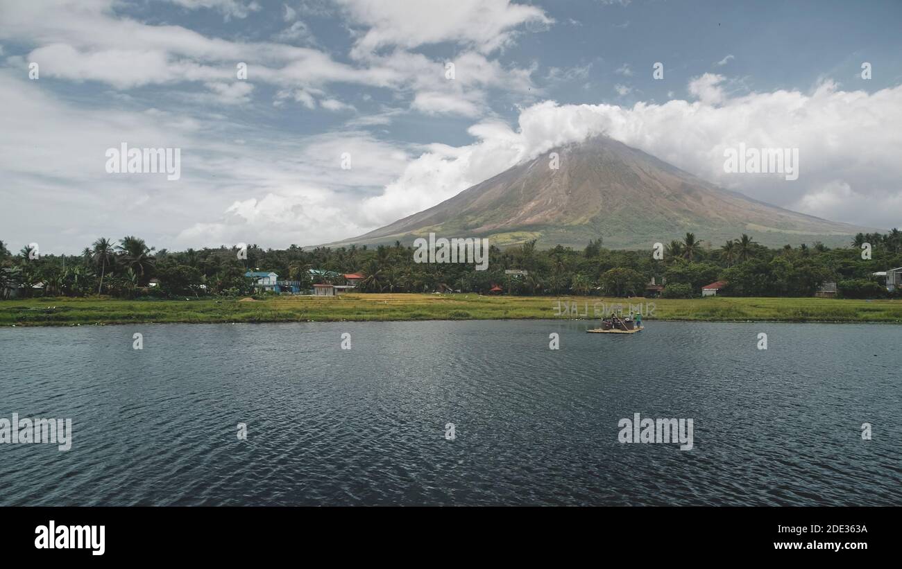 Tropic volcano at lake coast aerial. Tourist cruise at boat at green ...