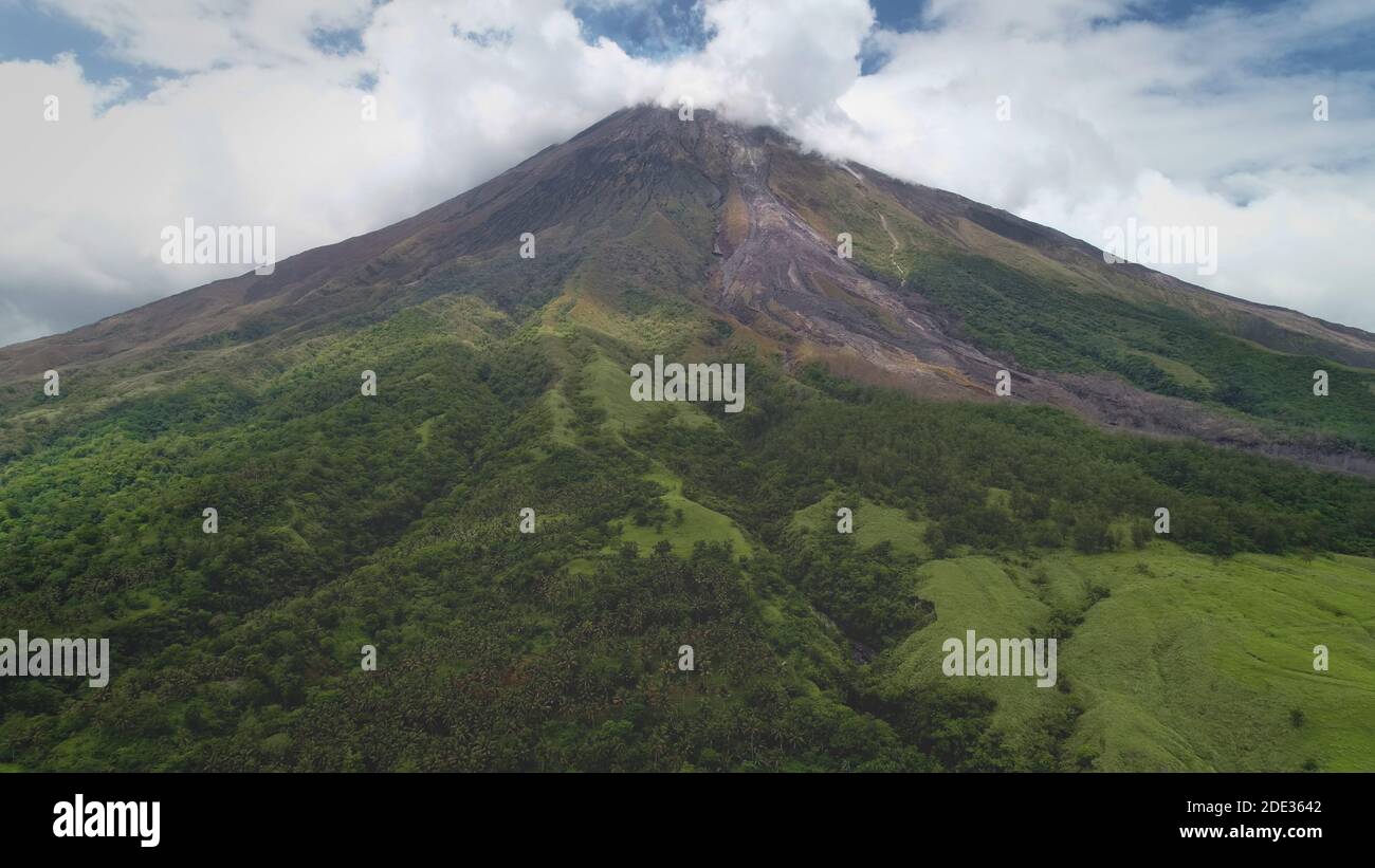 Closeup volcano top erupt clouds of haze aerial. Green grass mountain ...