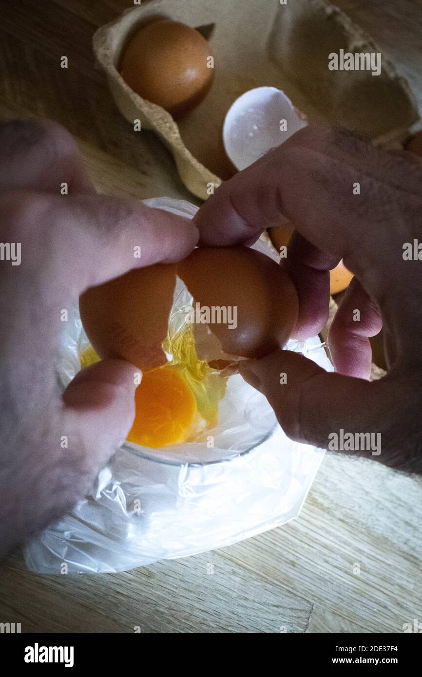A vertical shot of hands cracking an egg Stock Photo - Alamy