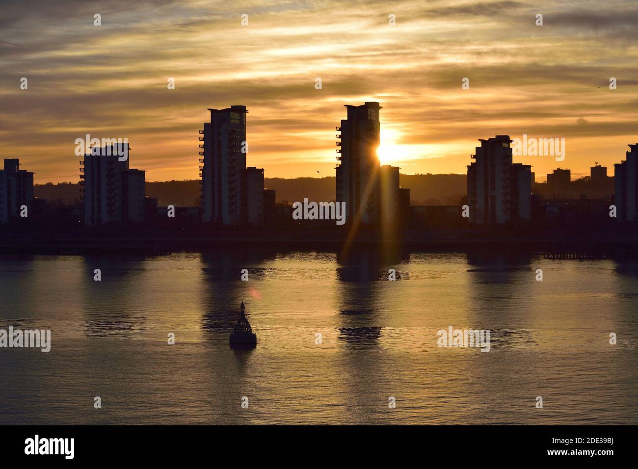 Golden sunrise with high-rise apartments next to the River Thames in ...