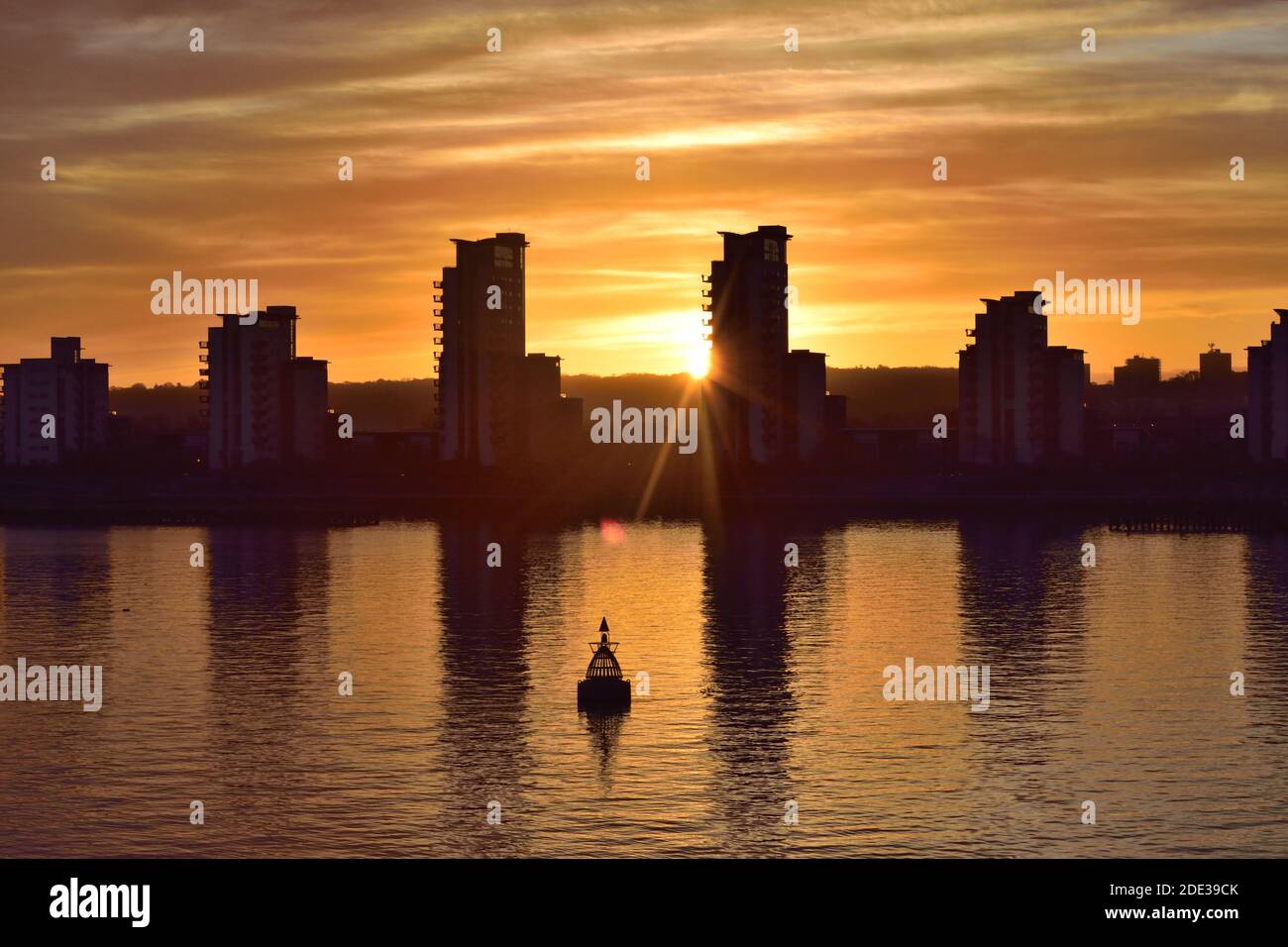 Golden sunrise with high-rise apartments next to the River Thames in ...