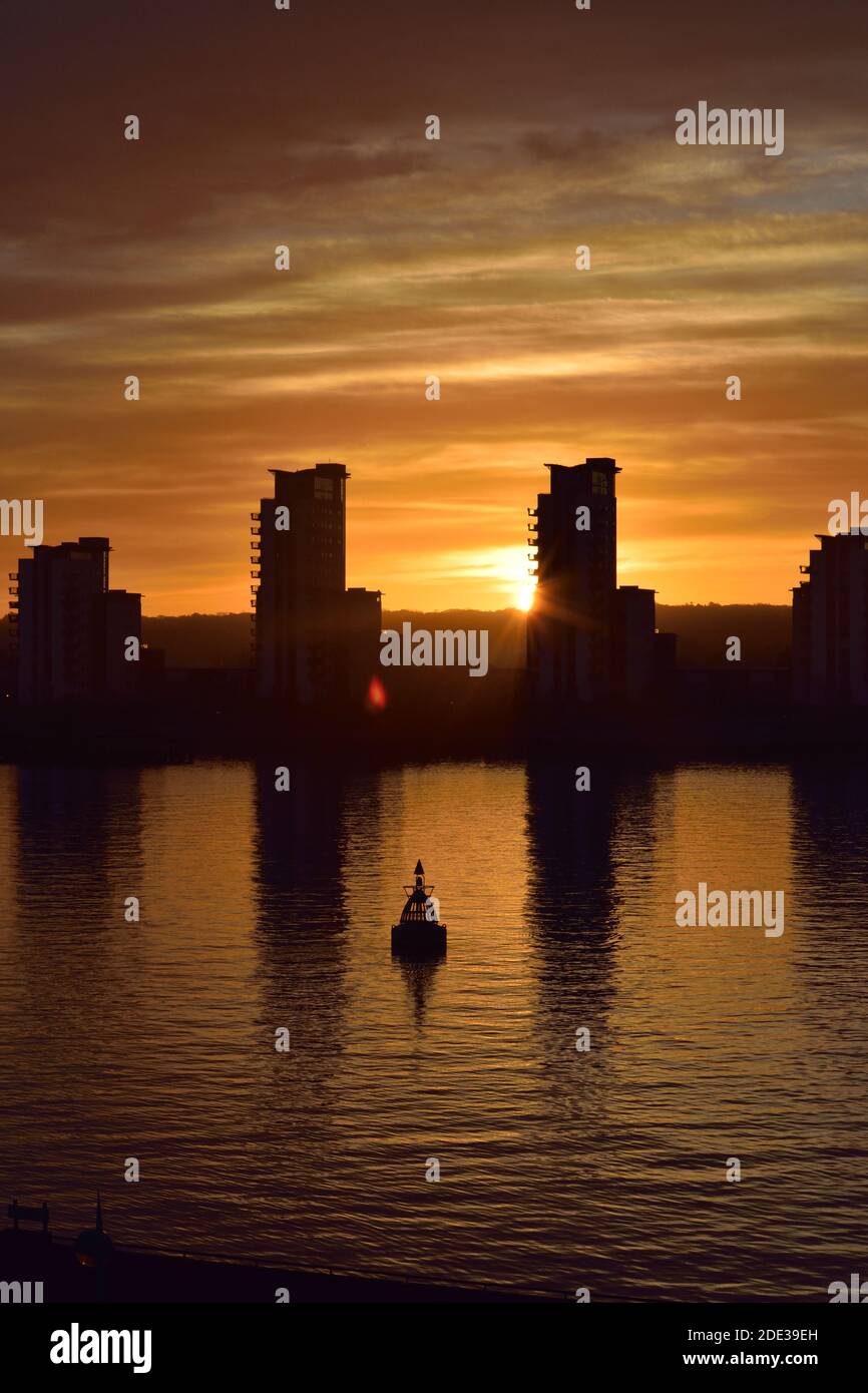 Golden sunrise with high-rise apartments next to the River Thames in ...