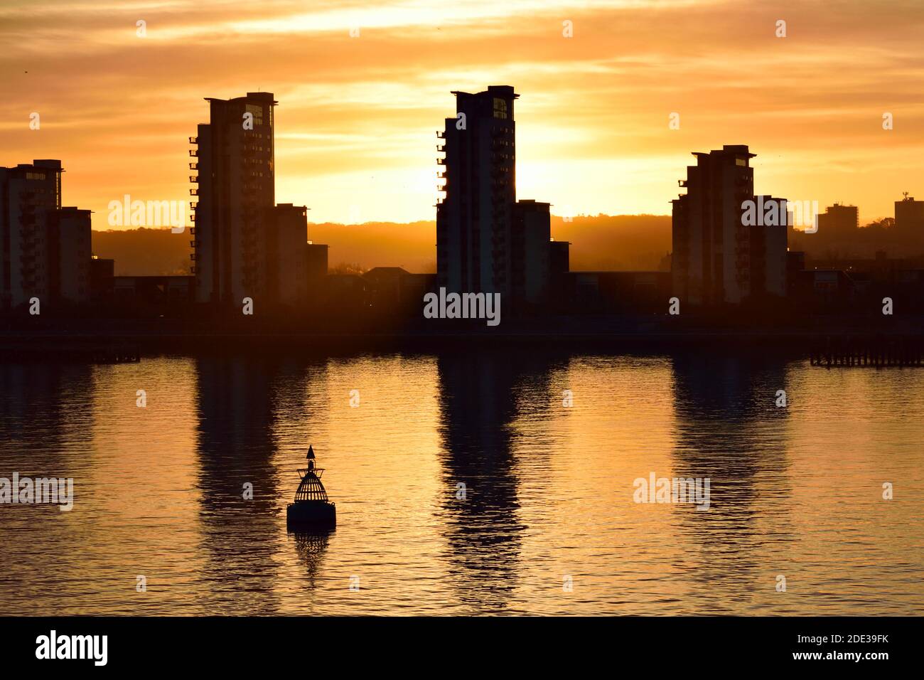 Golden sunrise with high-rise apartments next to the River Thames in ...