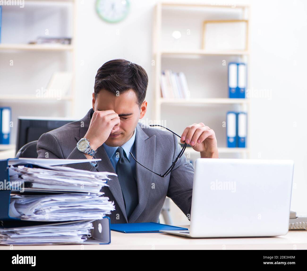 The overloaded with work employee under paperwork burden Stock Photo ...