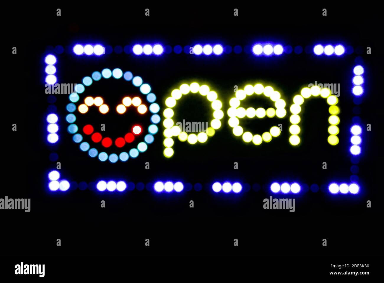 LED sign saying OPEN with smiley face in a local business window Stock ...