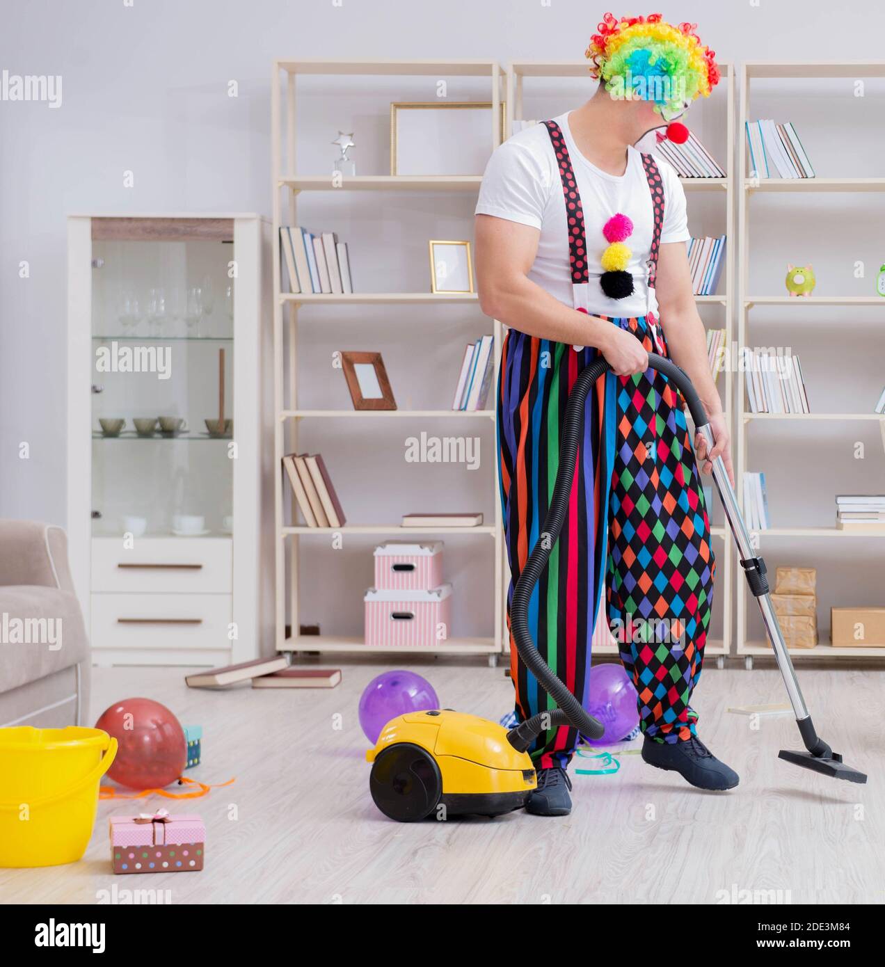 The funny clown doing cleaning at home Stock Photo - Alamy