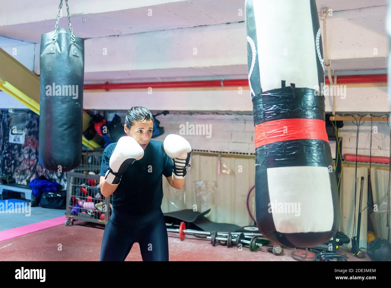 Female boxer hitting a huge punching bag at a boxing studio Stock Photo - Alamy