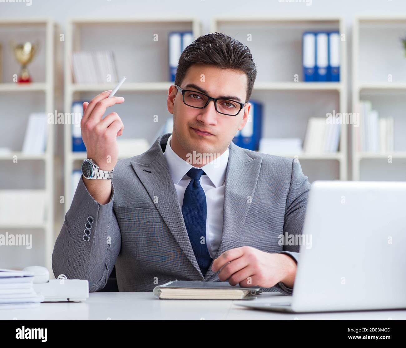 The businessman smoking in office at work Stock Photo - Alamy