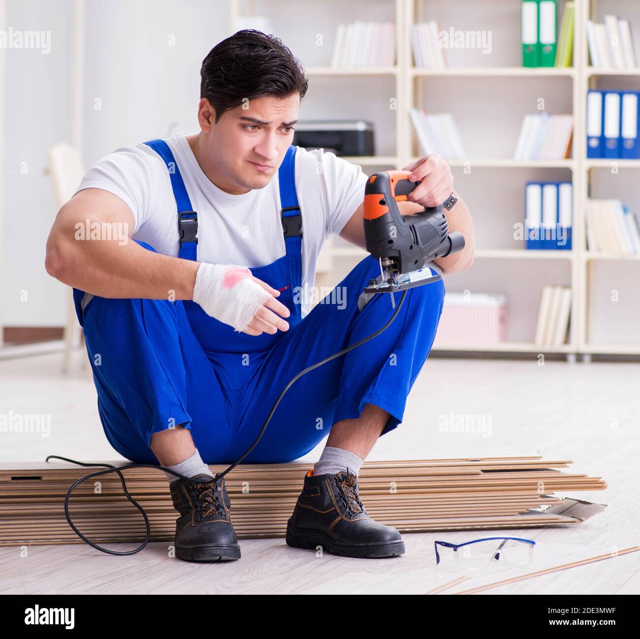 The young worker working on floor laminate tiles Stock Photo - Alamy