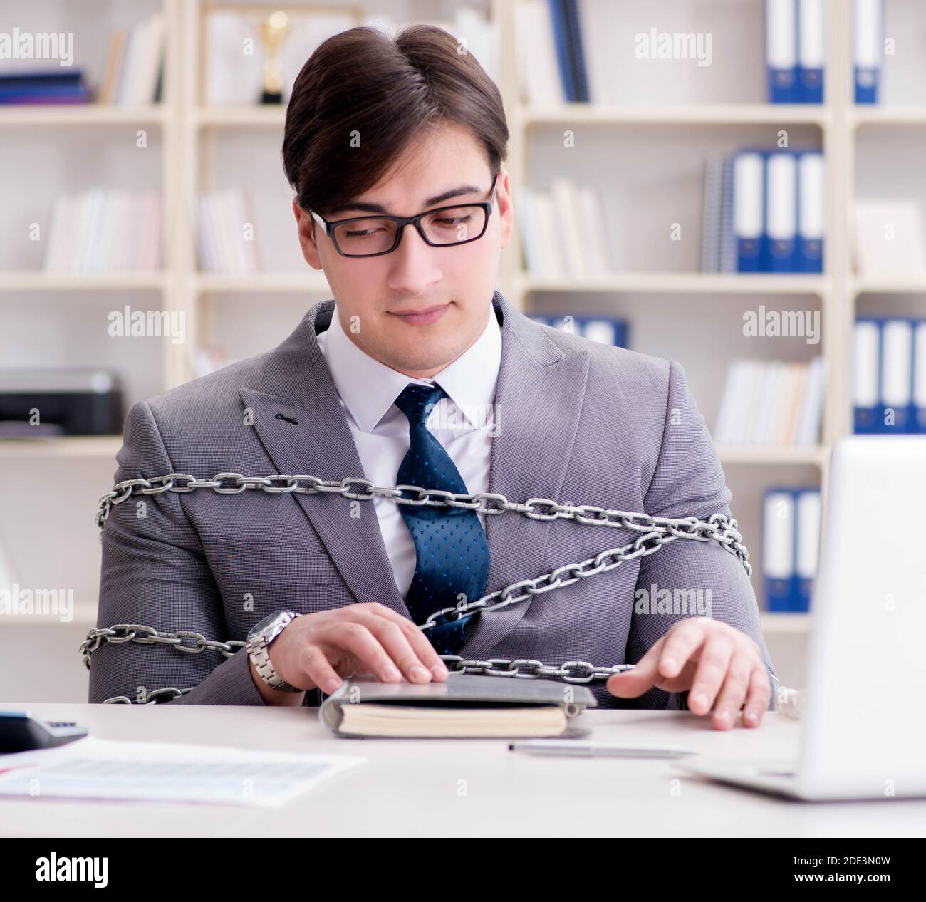 The businessman tied with chains to his work Stock Photo - Alamy