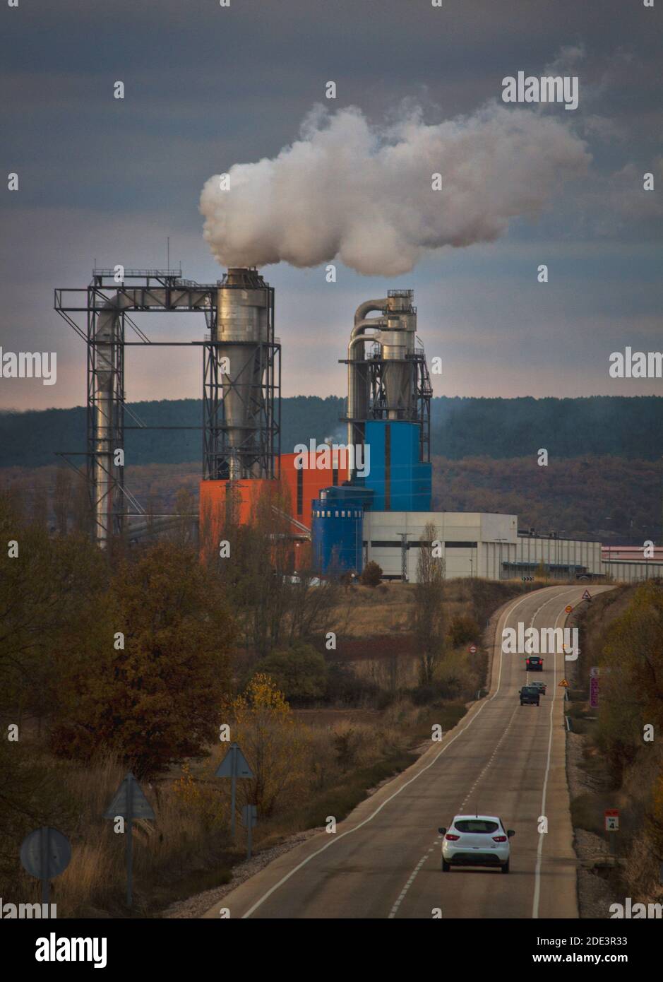 Wood factory with smoke and road with cars Stock Photo - Alamy