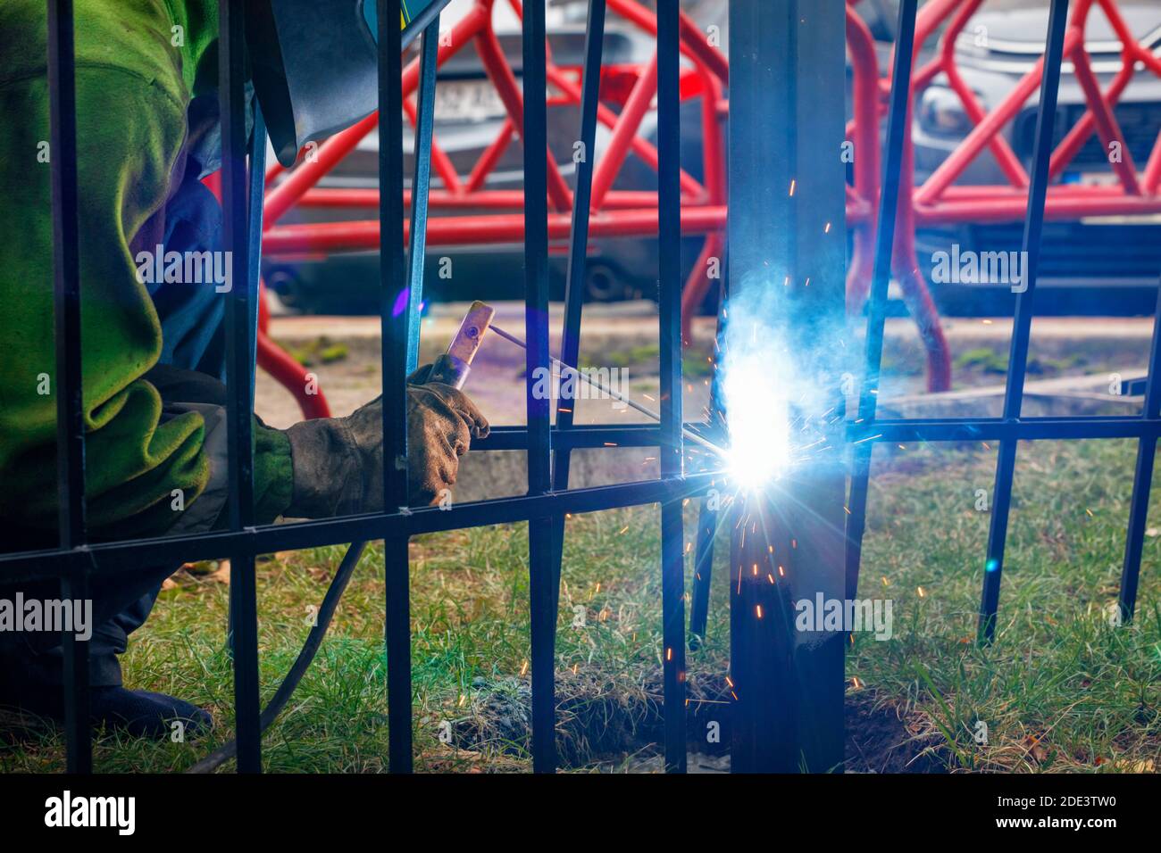 Bright sparks from electric welding scatter in different directions ...