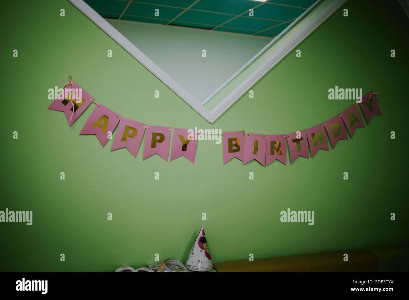 A "HAPPY BIRTHDAY" pink bunting paper banner hanging from a wall Stock ...