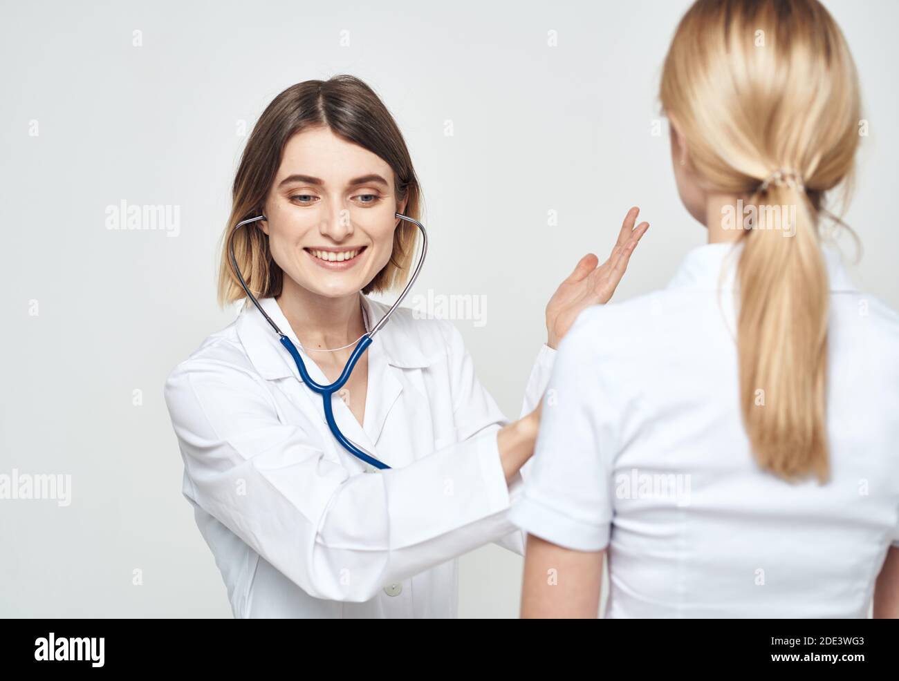 doctor woman in a medical gown with a stethoscope communicates with a ...