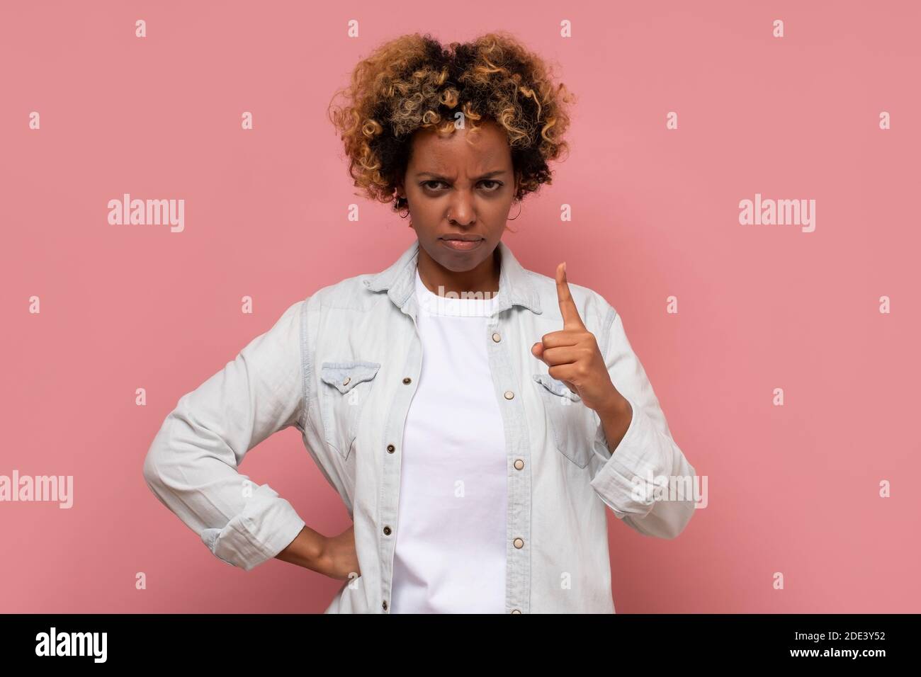 African woman pointing with finger up and angry expression, showing ...