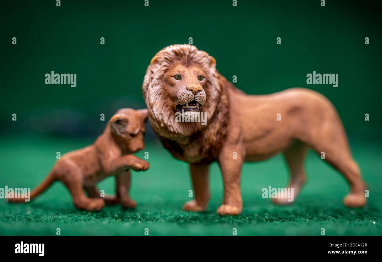 plastic figurines of lion playing with her cub in a savannah-like ...