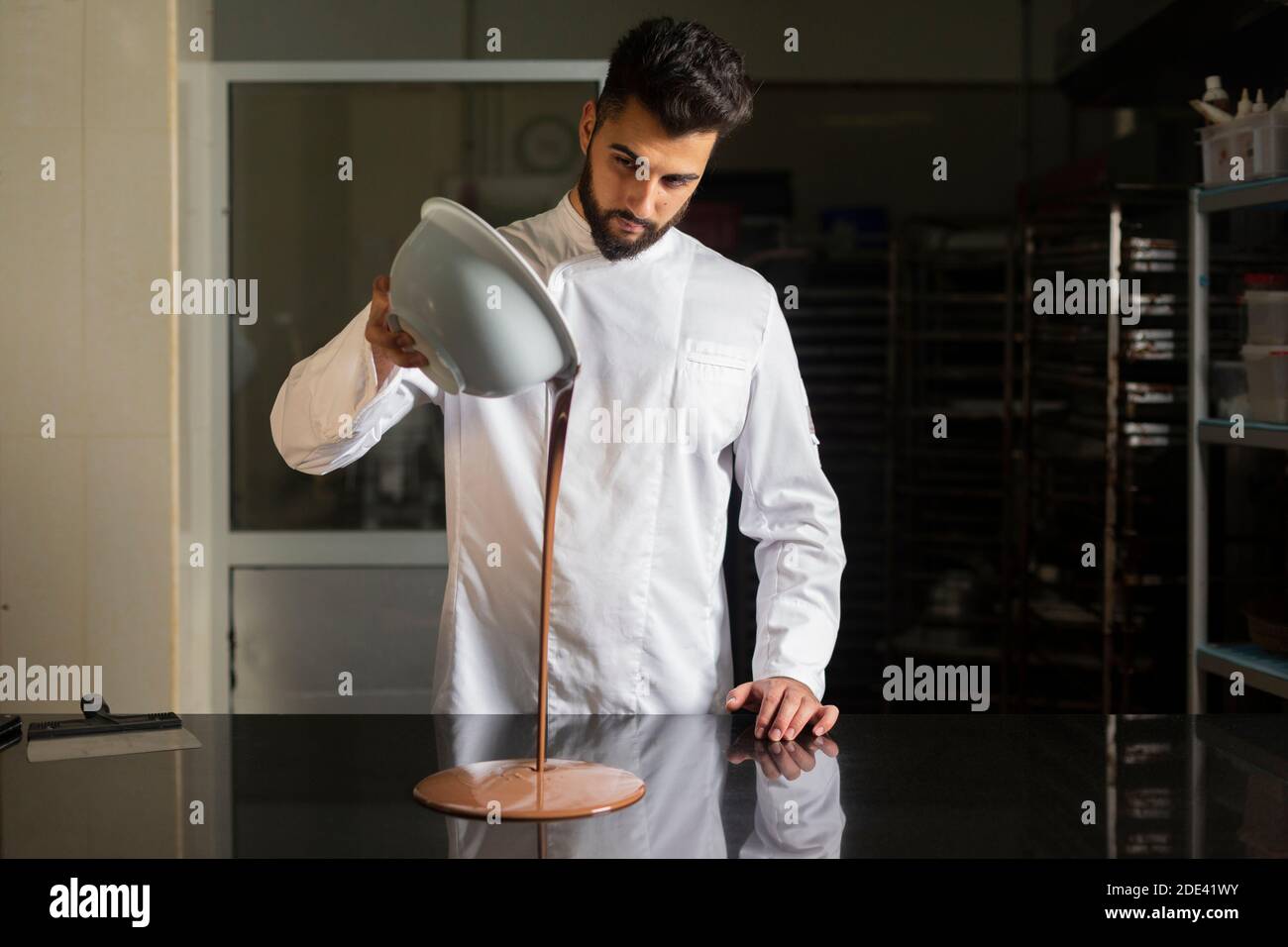 Pastry chef working on tempering chocolate on marble table Stock Photo ...