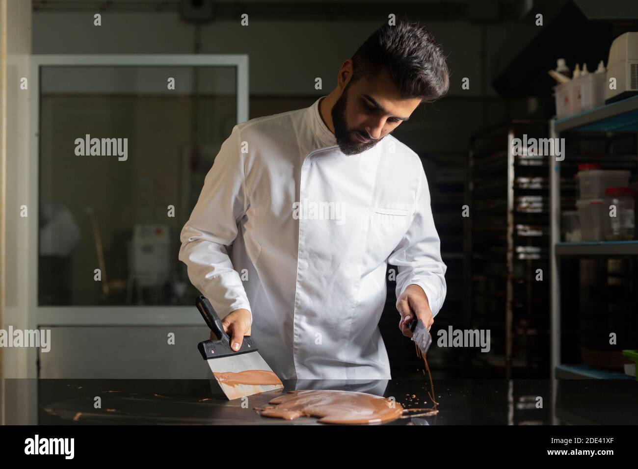 Pastry chef working on tempering chocolate on marble table Stock Photo ...