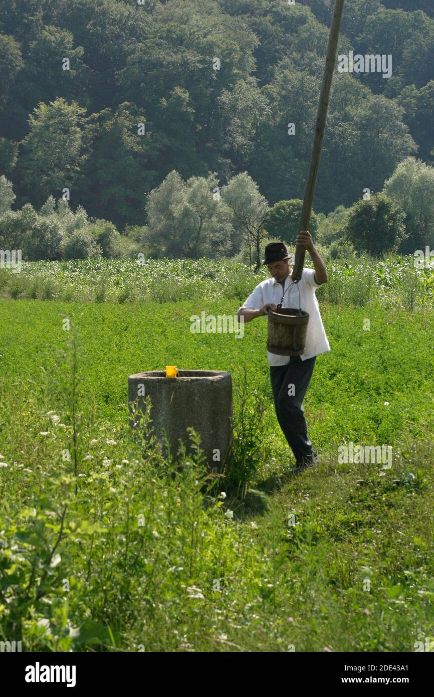 Man drawing water from a well hi-res stock photography and images - Alamy