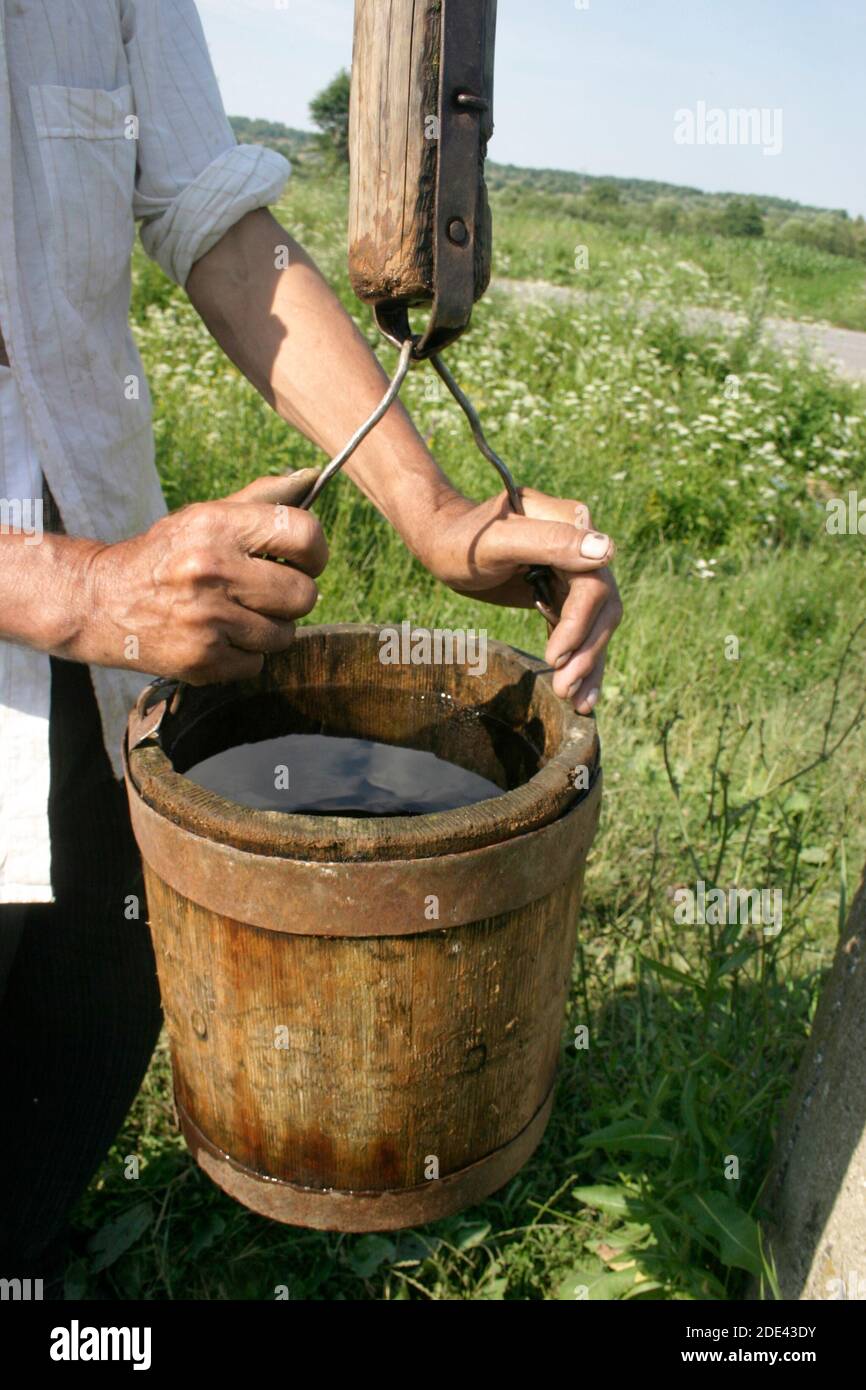 Man in Romania's countryside drawing water from a well Stock Photo - Alamy