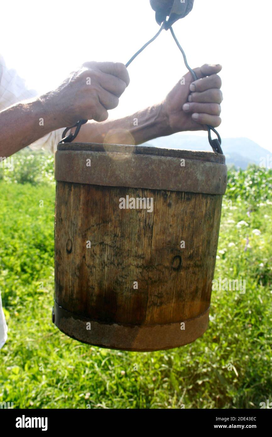Man in Romania's countryside drawing water from a well Stock Photo - Alamy